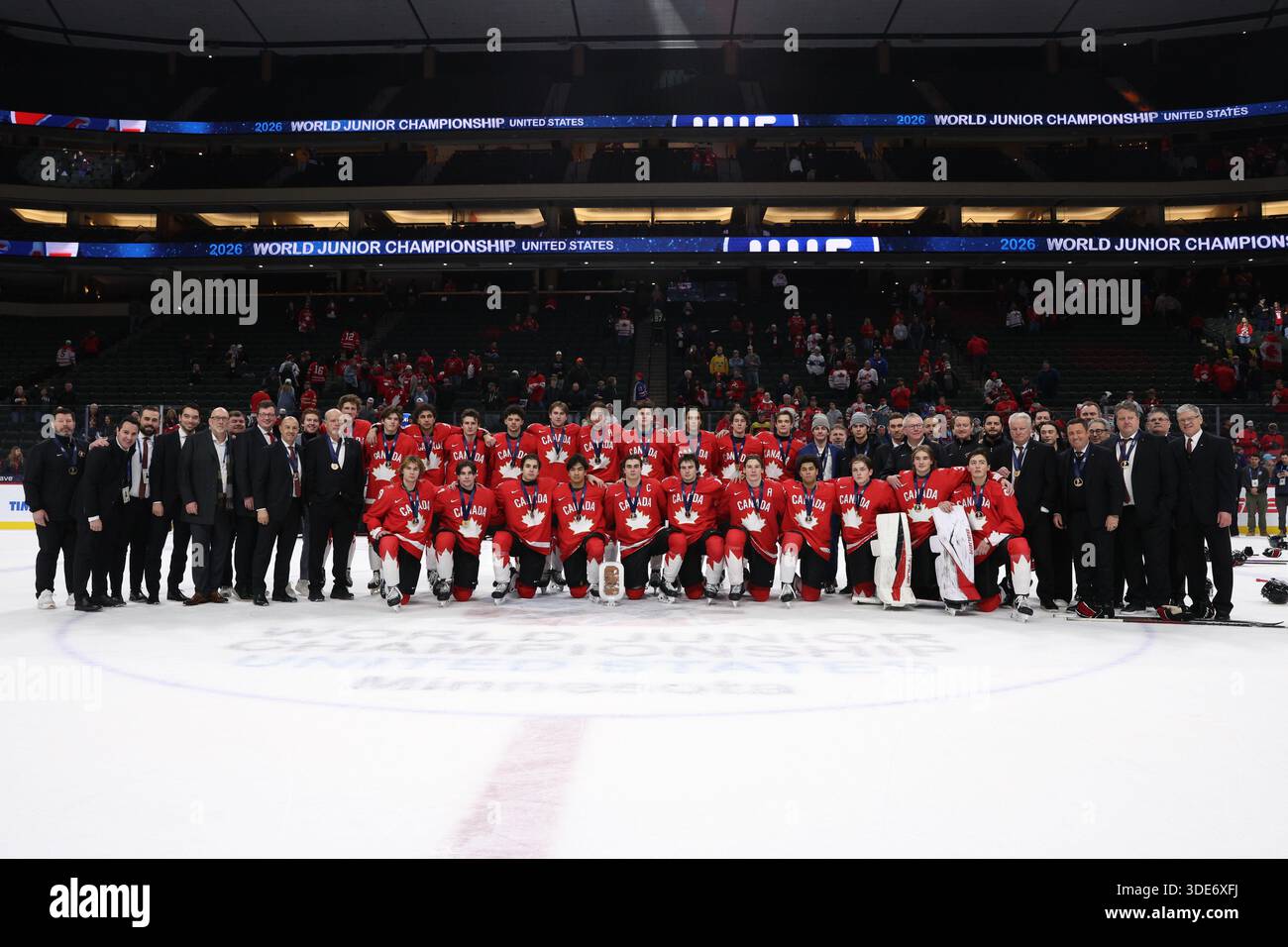 Canada players and coaches pose for photos after winning during an IIHF ...
