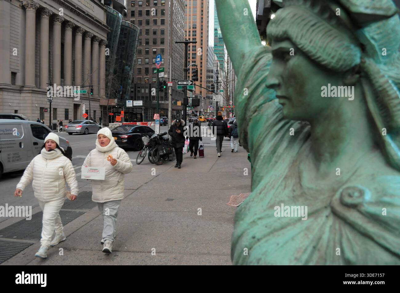 People walk past a model of the Statue of Liberty outside of a store in ...
