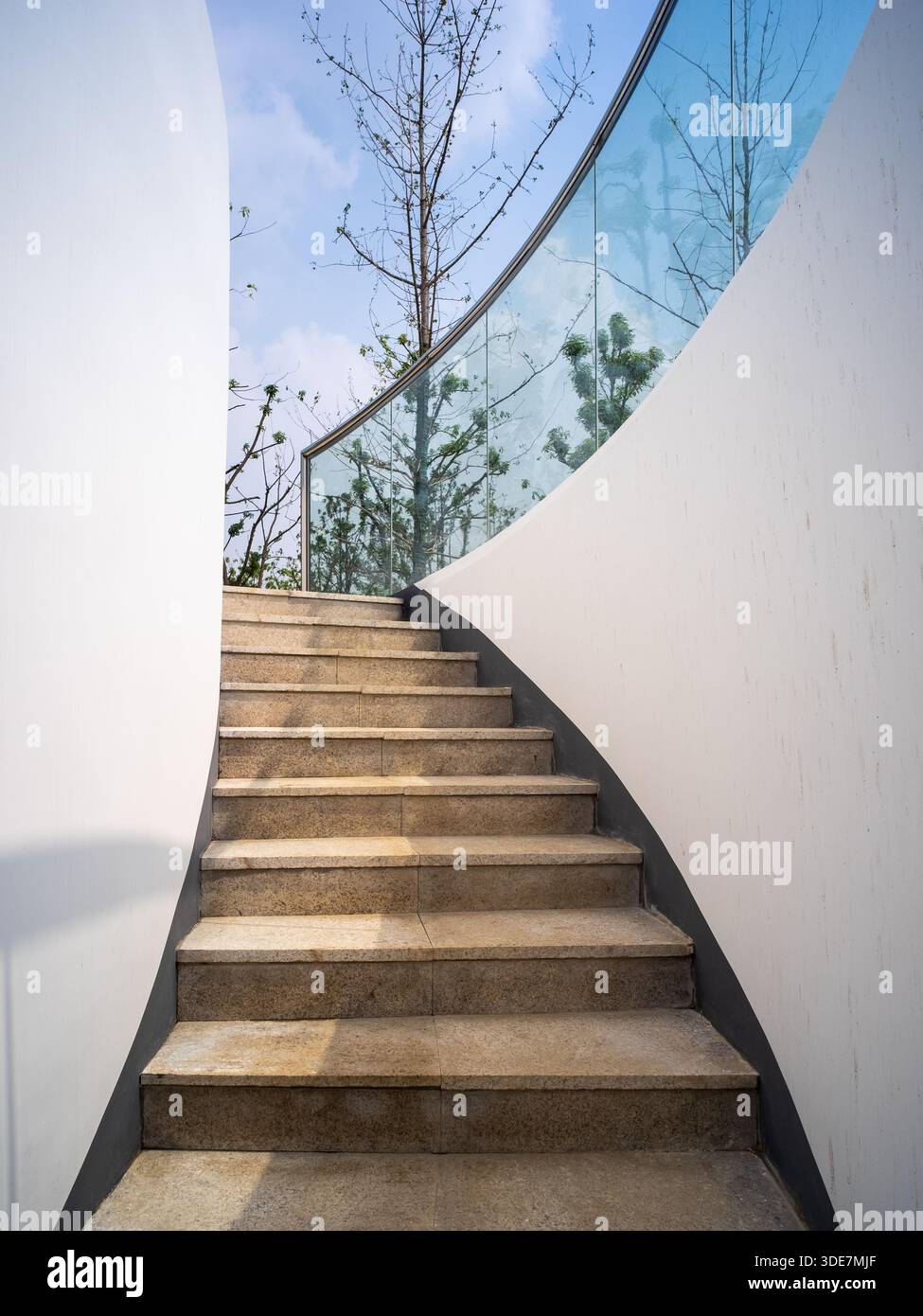 Vertical low angle view of a modern curved stone staircase leading ...