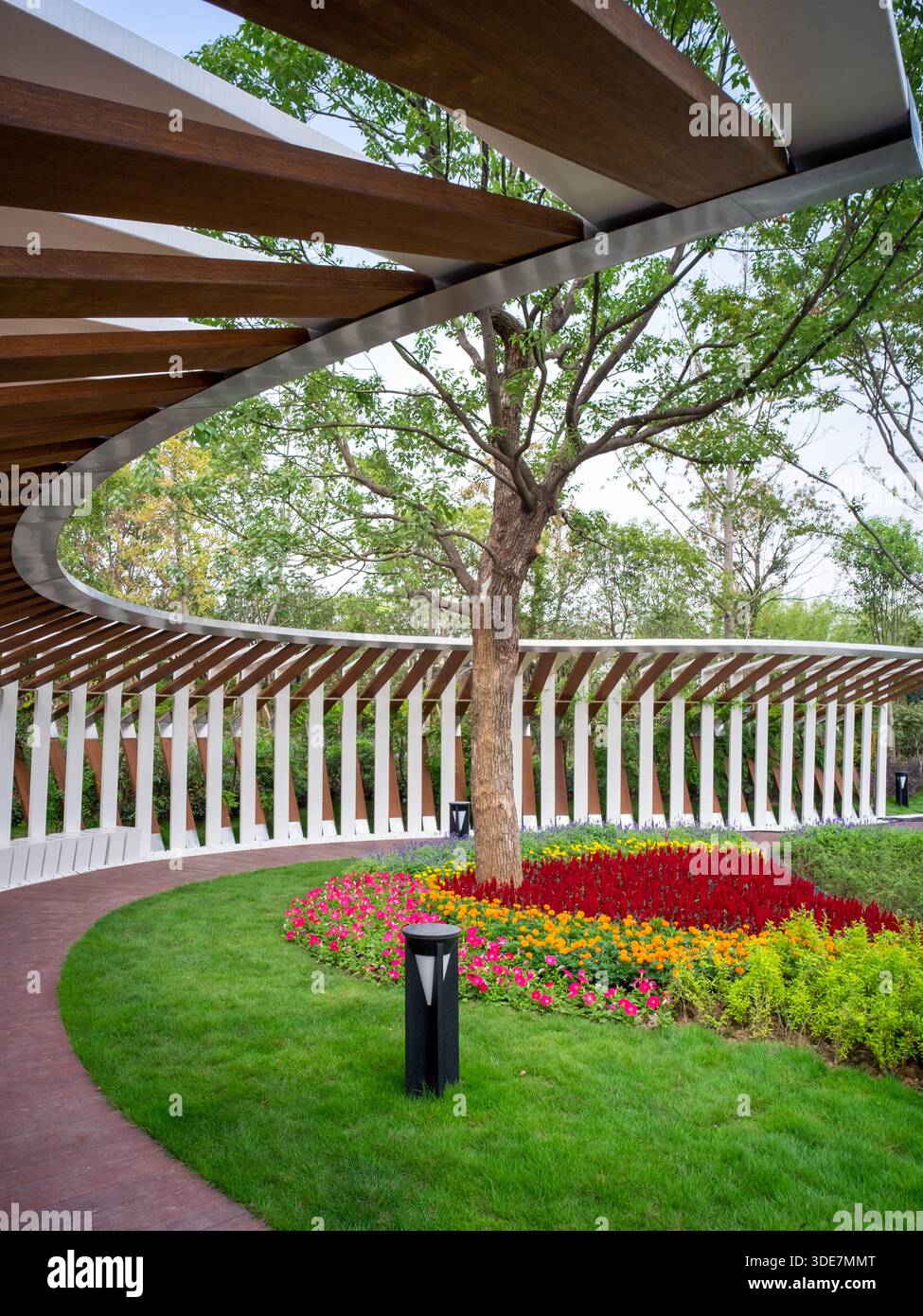 Vertical view of a curved wooden pergola or trellis structure providing ...