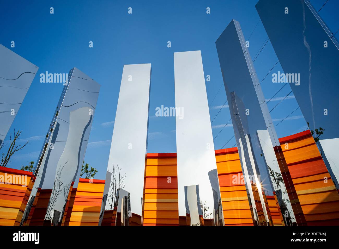 Low angle perspective looking up at a group of tall mirrored pillars ...