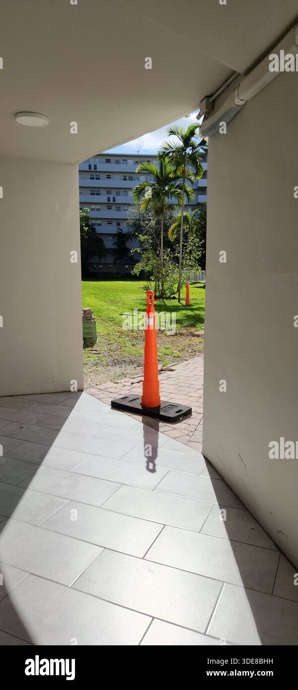 This image shows a tall orange warning cone, commonly used in road and ...