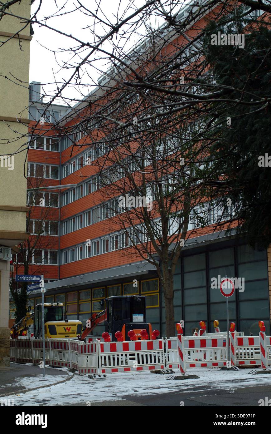 urban construction site with snow barriers, orange brick office block ...