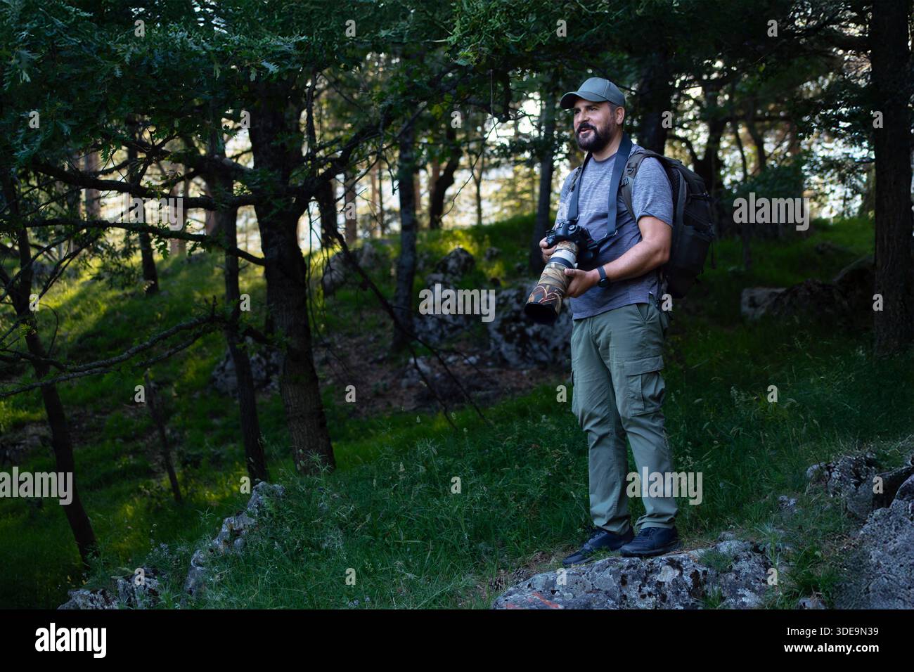 The nature photographer in the forest with a telephoto lens and a ...