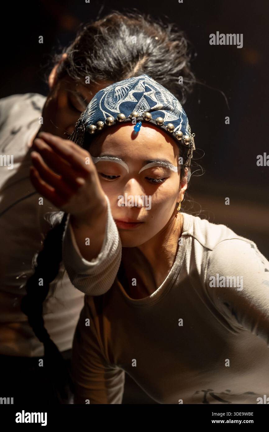 A dramatic portrait of 2 female dancesr captured mid-performance ...