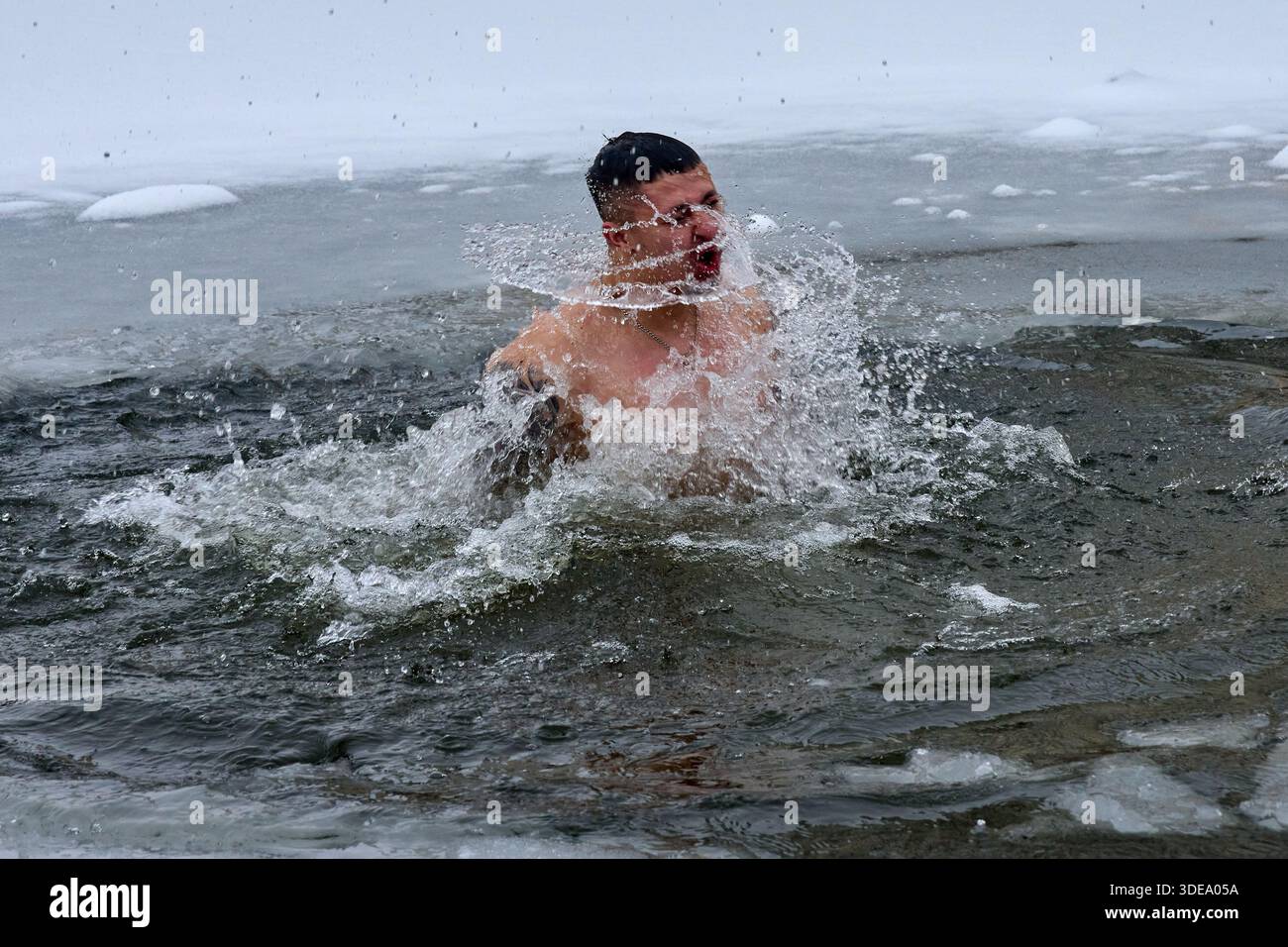A man enjoys icy water during celebrations of Epiphany in Kyiv, Ukraine ...