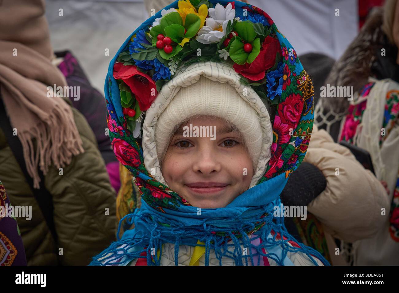 A girl watches people plunging into icy water during celebrations of ...