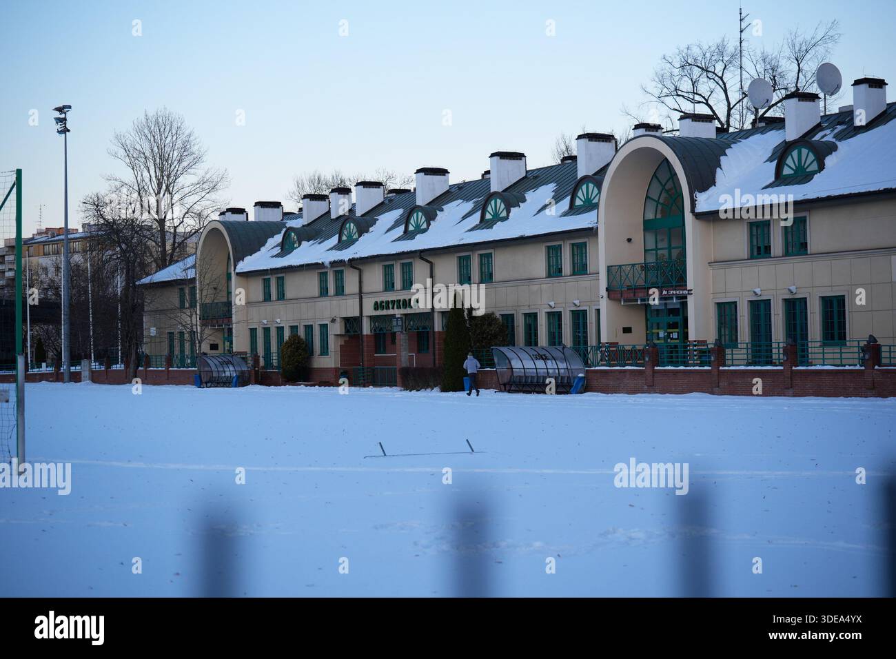 A man is seen exercising on a snow covered running track in Warsaw ...