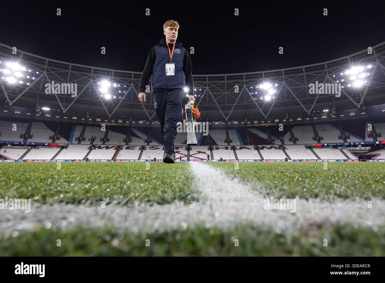 A groundsman is seen working on the pitch inside the stadium prior to ...