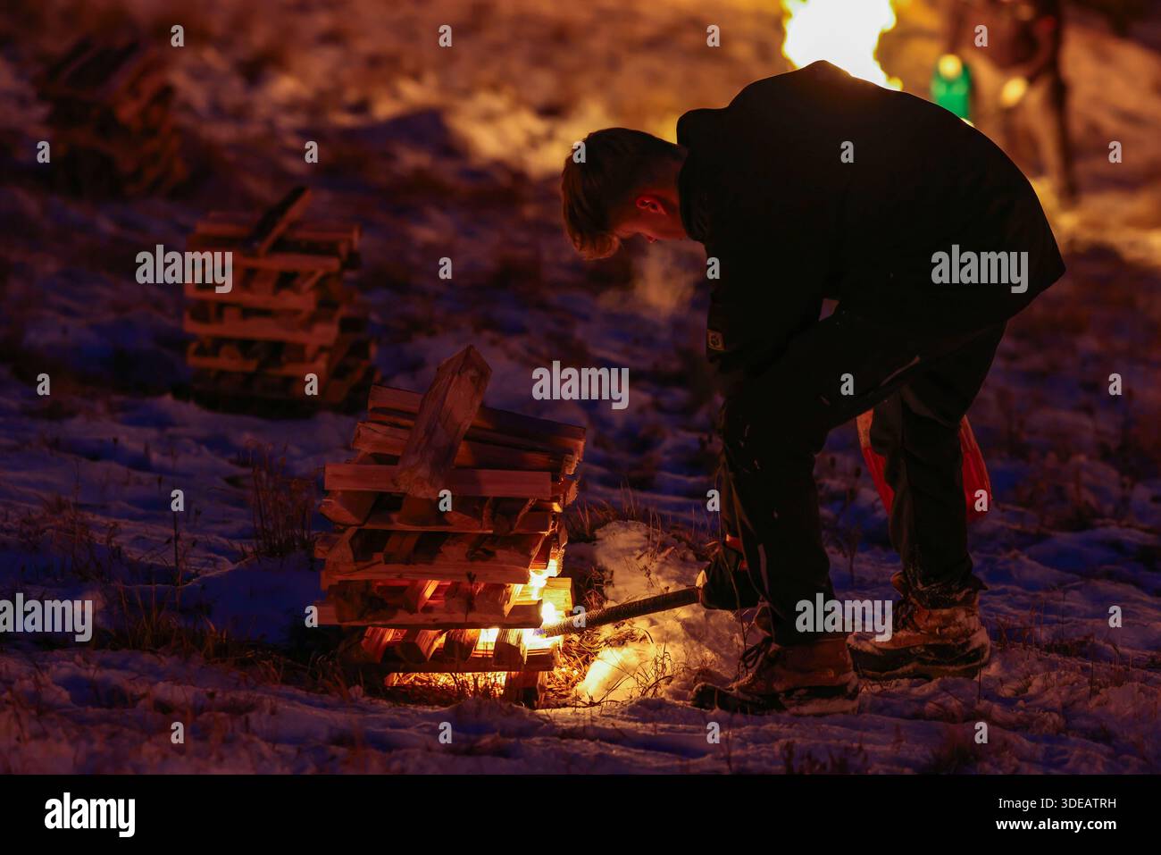 06 January 2026, Bavaria, Pottenstein: A fire-stoker lights one of the ...