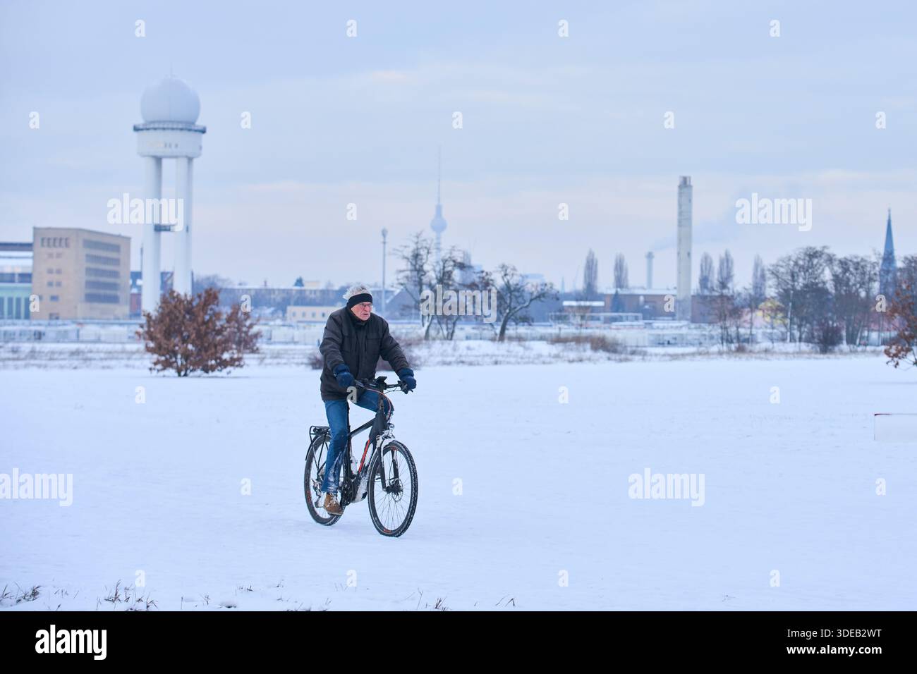 A man rides a bicycle in the snow as winter weather covers the city in Berlin, Germany, Tuesday ...