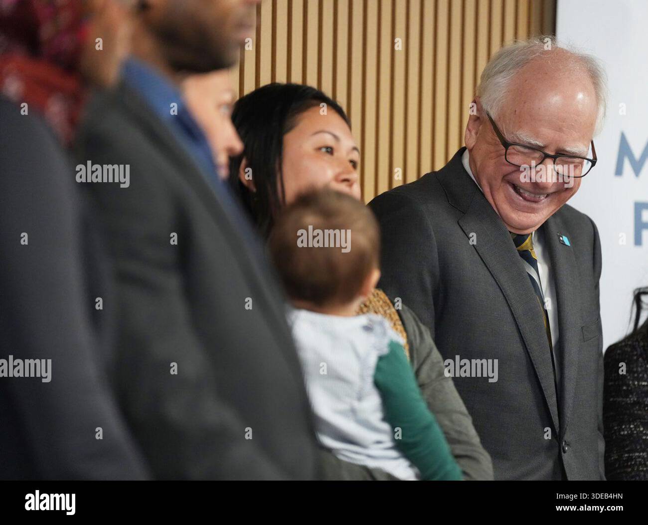 Gov. Tim Walz smiles at a child before speaking during a press ...