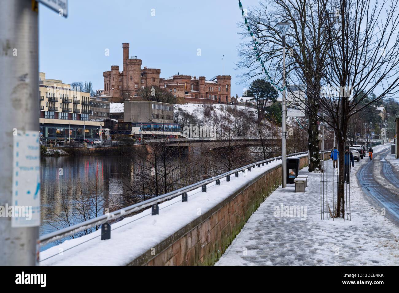 Snow covers the ground as shadows fall on the River Ness. Inverness ...