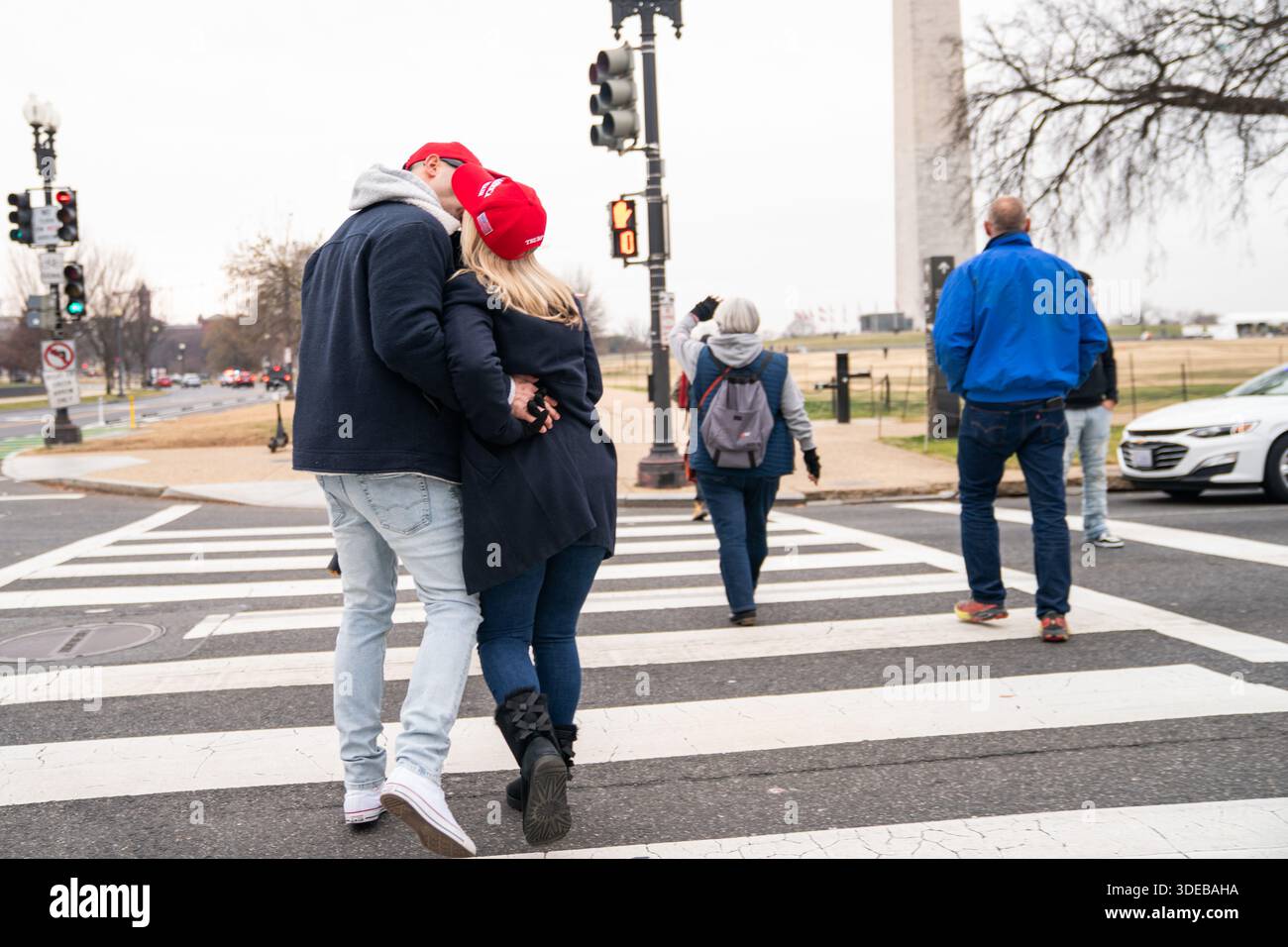 A couple kiss as they cross a street near the Washington Monument ...