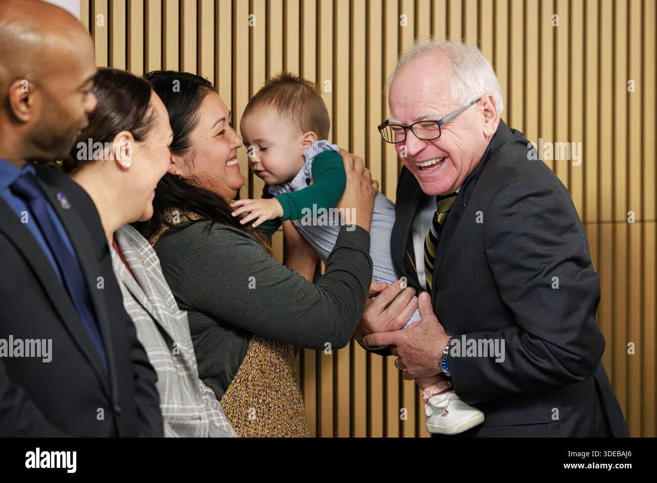 Gov. Tim Walz smiles at a child before speaking during a press ...