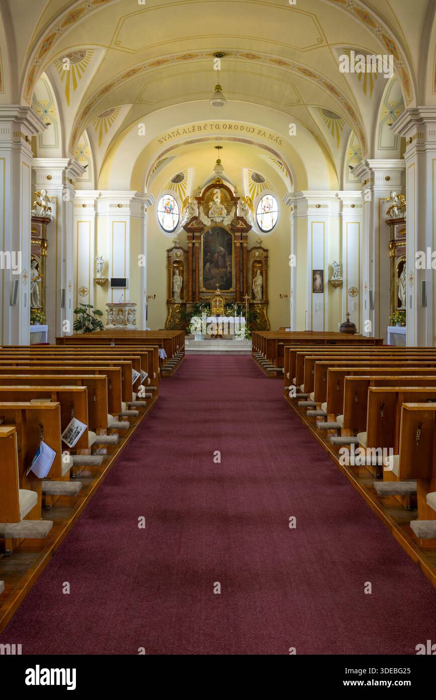 Ornate church interior showing rows of wooden pews and religious altar ...