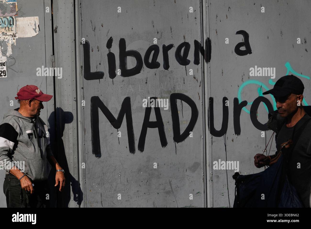 People walk past graffiti that reads in Spanish, "Free Maduro," during ...