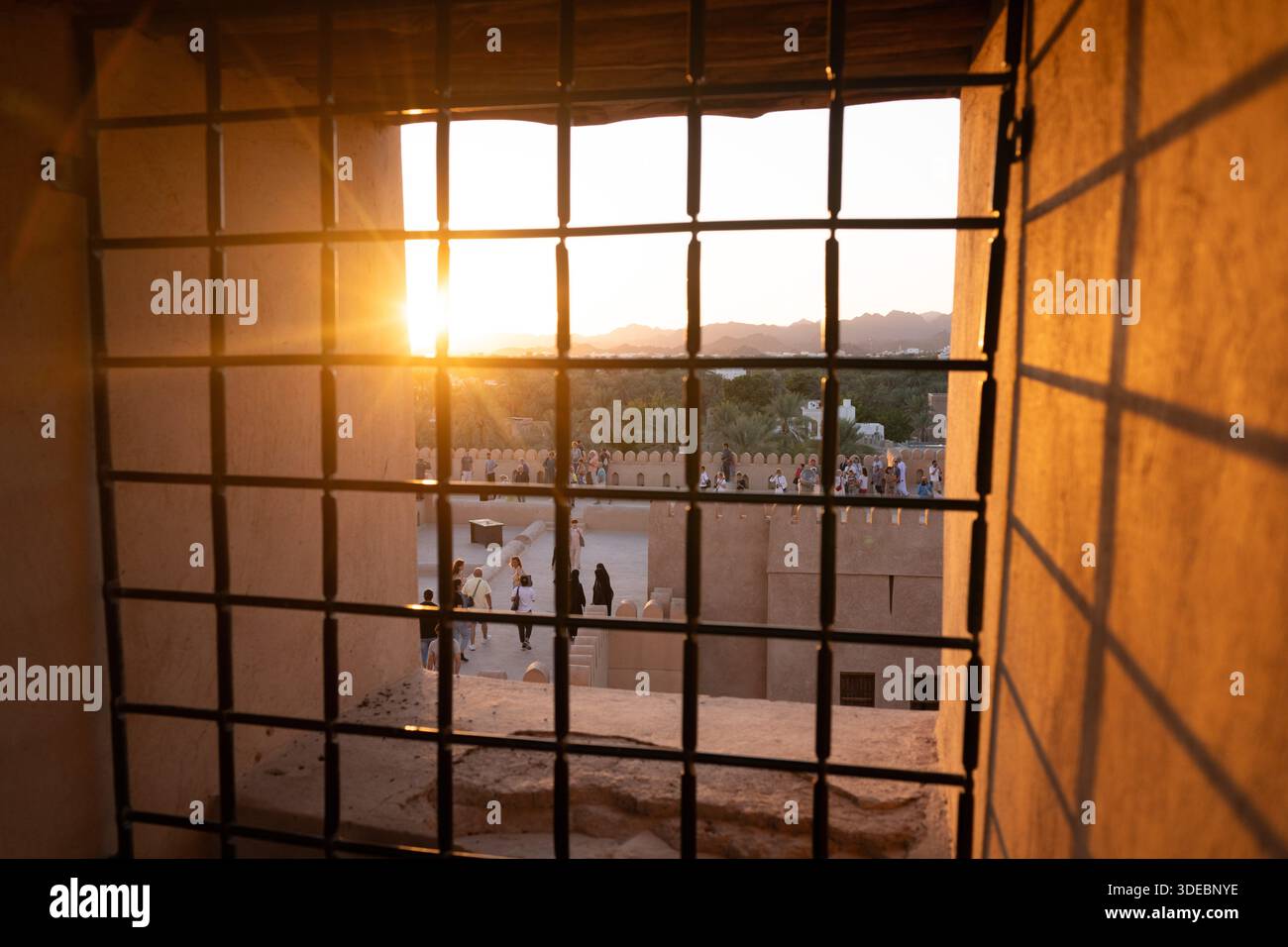 18 November 2025, Oman, Nizwa: Sunset view from the fort through a ...
