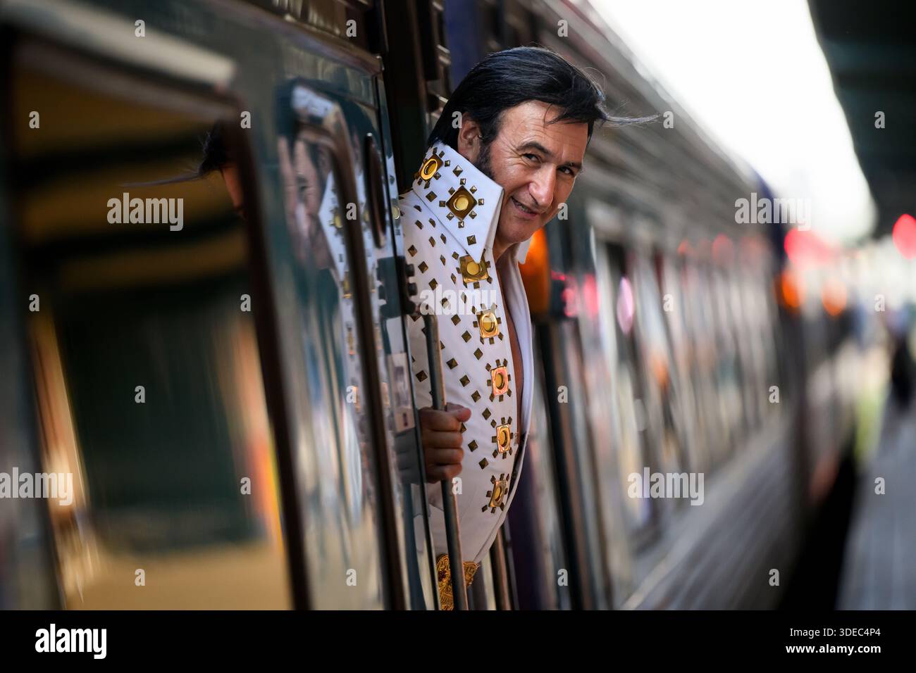 A fan dressed as Elvis Presley waits for the departure of the Elvis ...