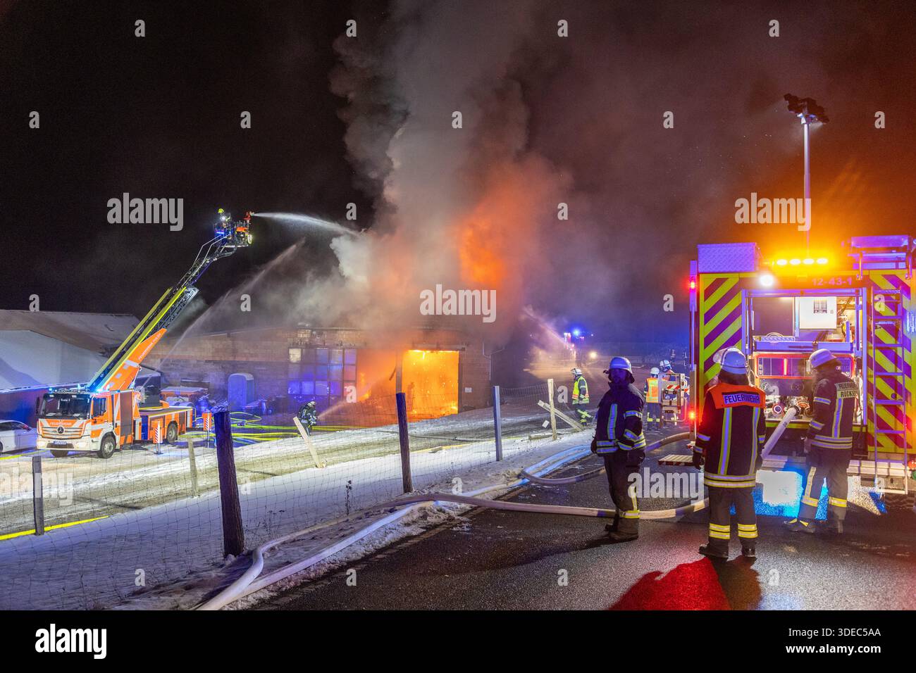 06 January 2026, Hesse, Flieden: Firefighters fight a fire in a ...