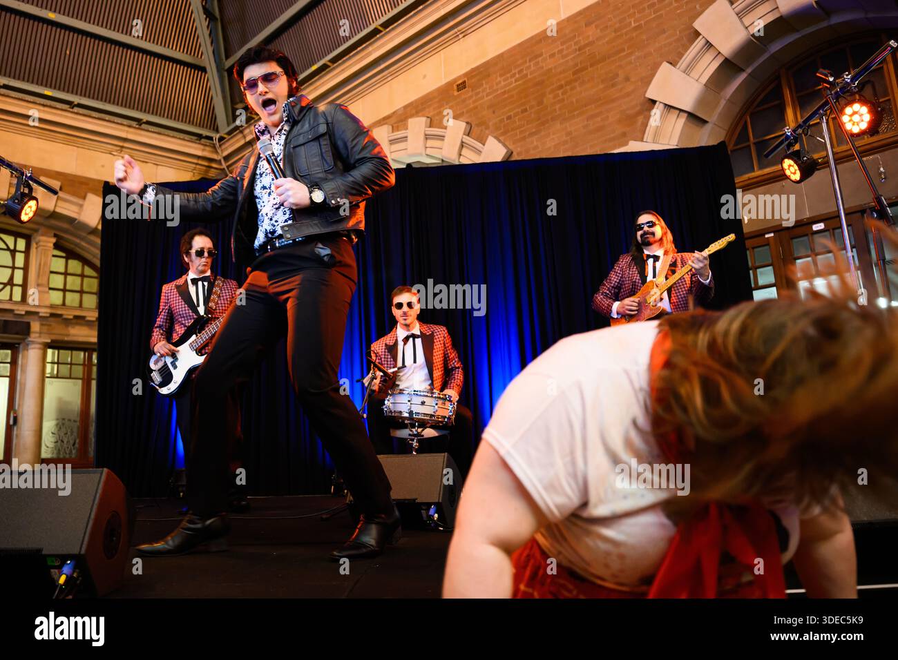 A fan dressed as Elvis Presley performs ahead of the departure of the ...