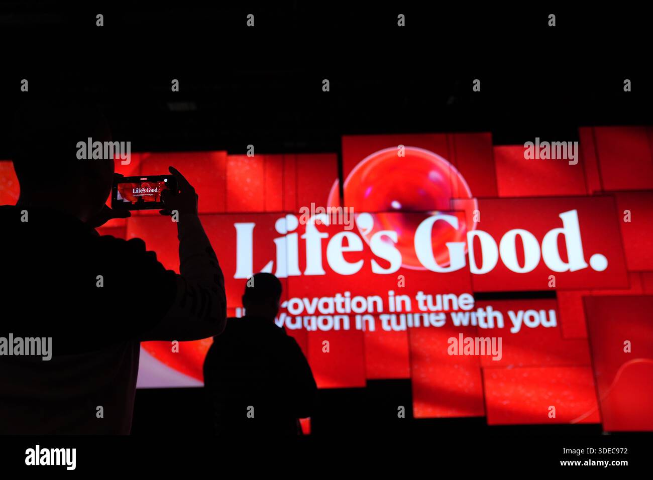People walk past screens at the LG Electronics booth during the CES ...