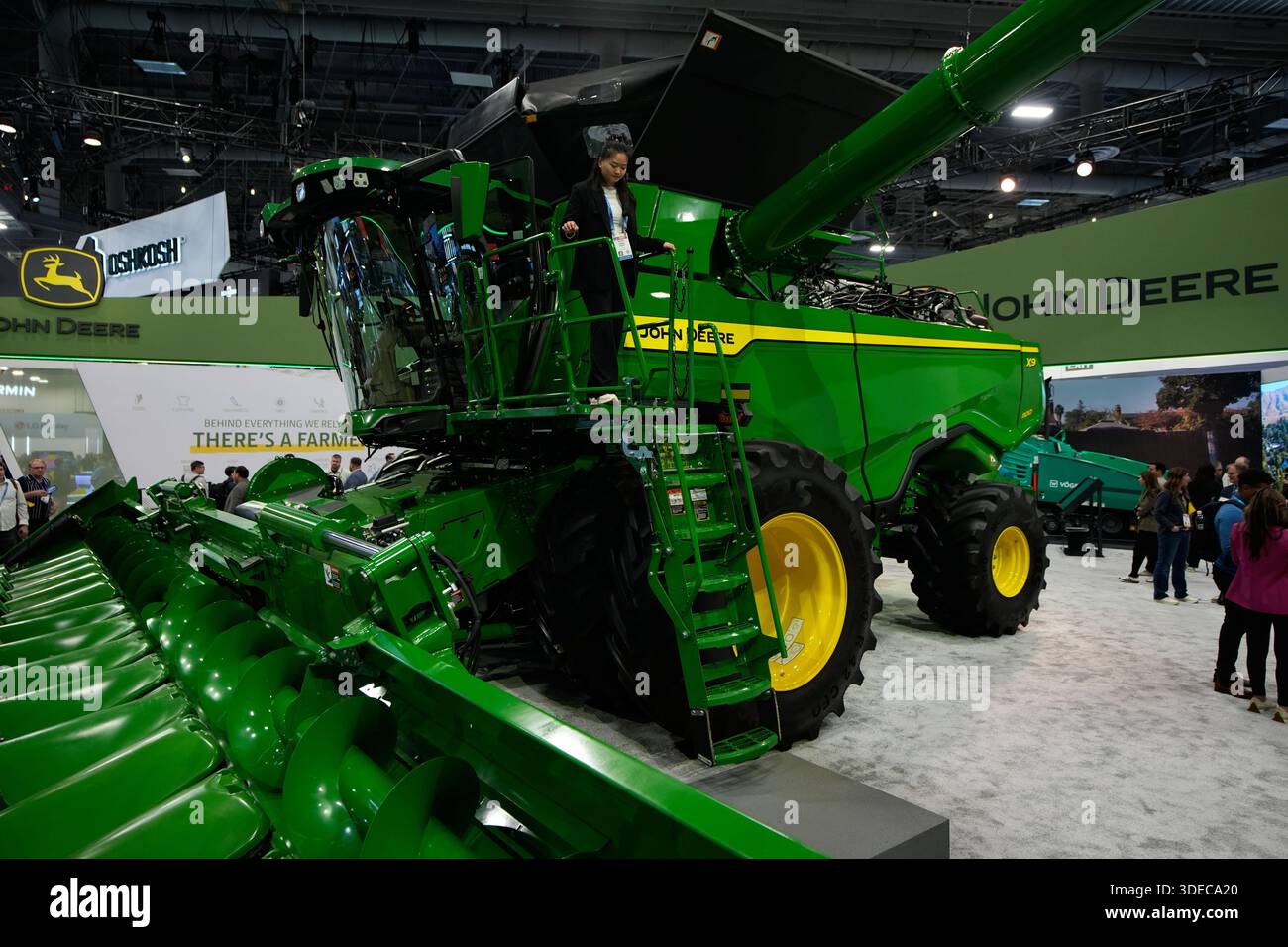 A person walks on an X9 1100 combine at the John Deere booth during the ...