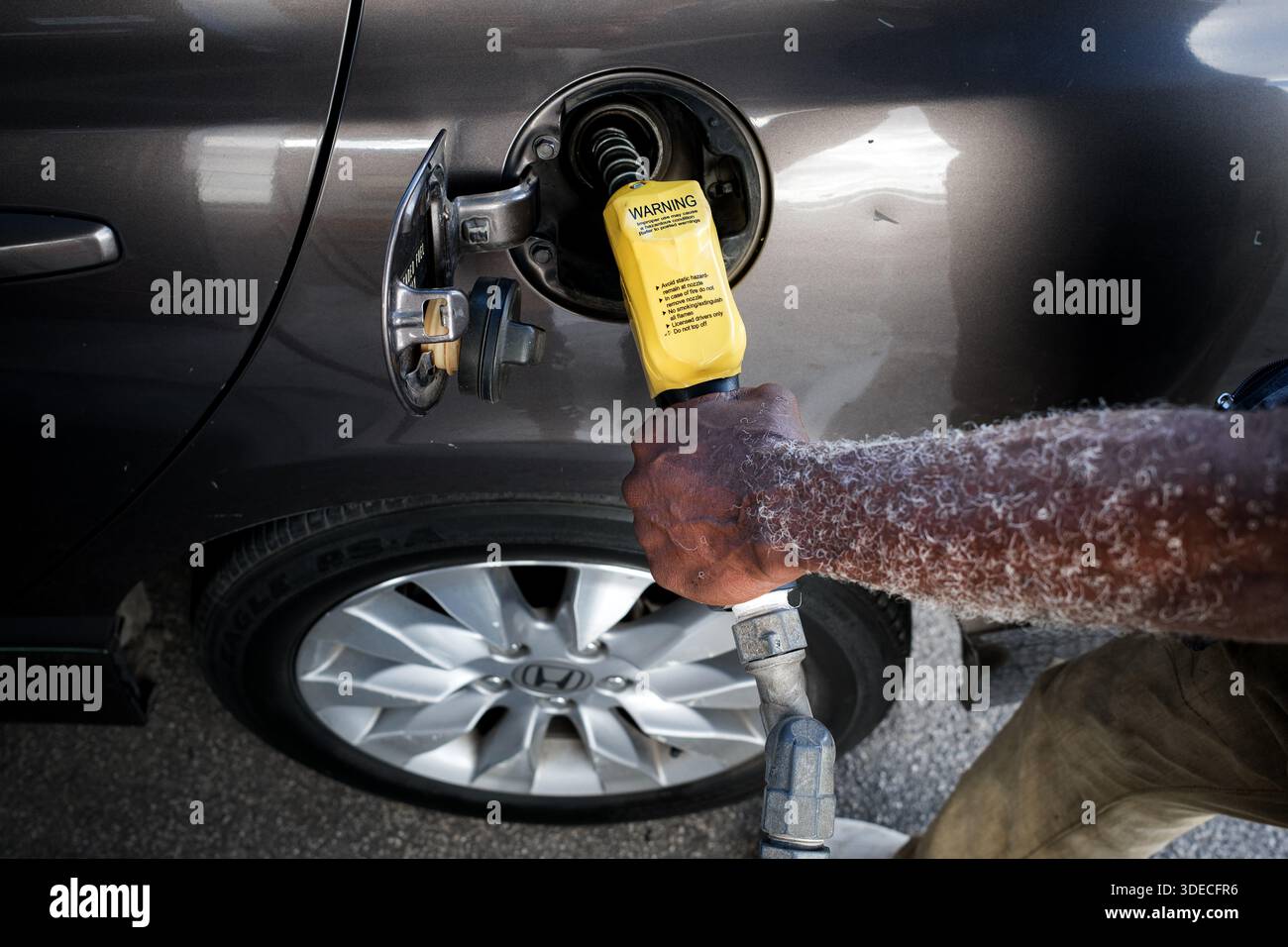 WILLEMSTAD - A man fills up his car's gas tank in downtown Willemstad ...