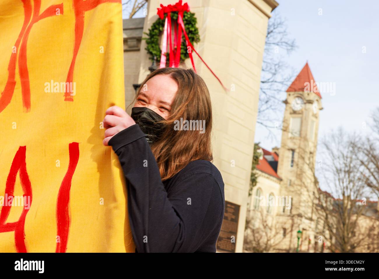 A protester holds a banner at Indiana University’s Sample Gates during ...