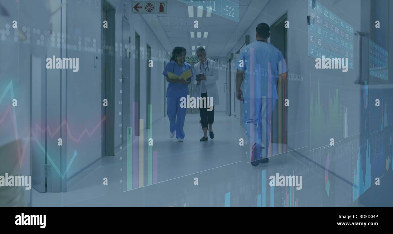 Walking clinic team in scrubs and coat reviewing data in hospital ward ...