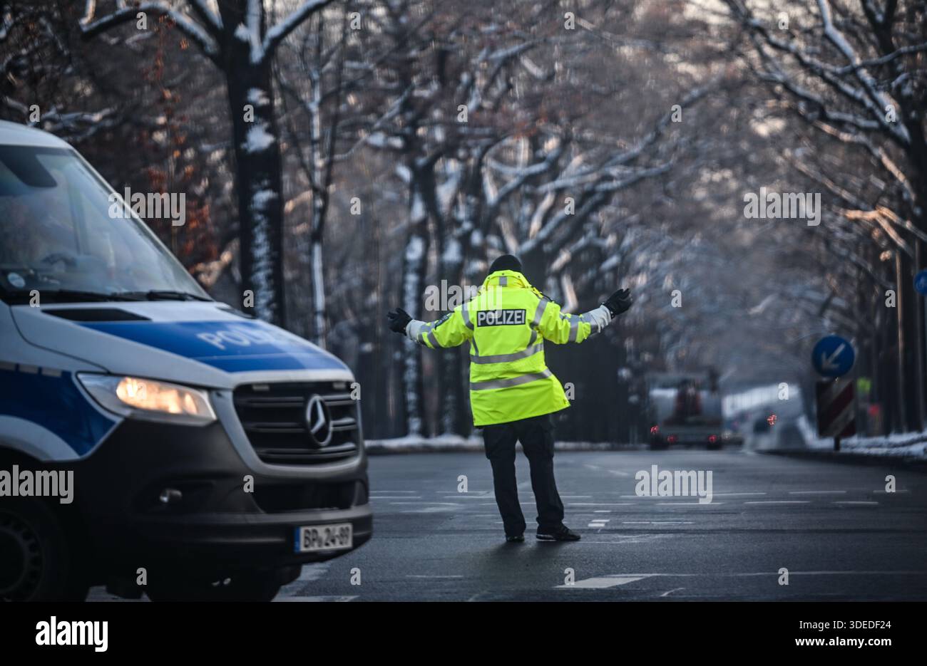 07 January 2026, Berlin: A police officer directs traffic at a junction ...