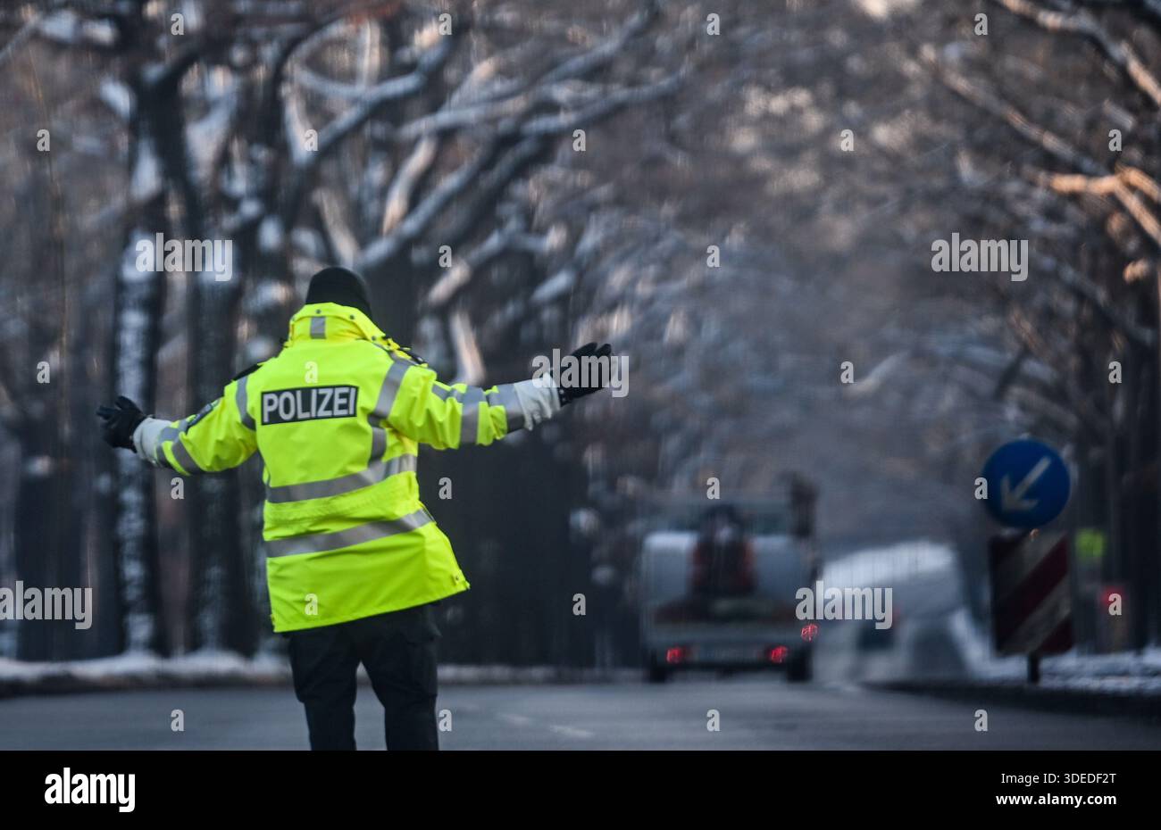 07 January 2026, Berlin: A police officer directs traffic at a junction ...