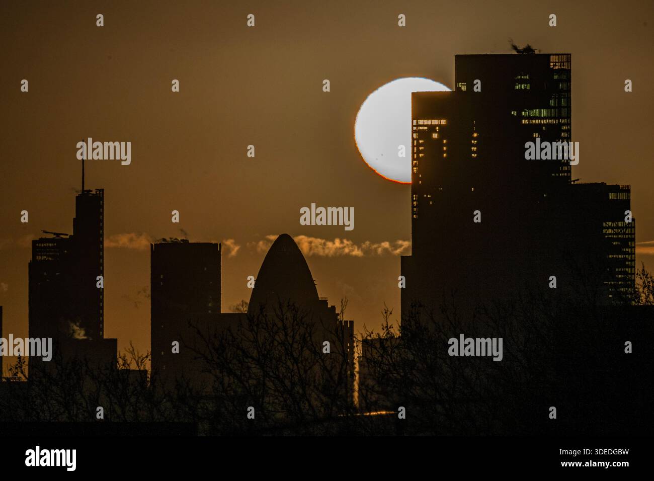 London, UK. 7 Jan 2026. The sky glows orange as the Sun rises in cold ...