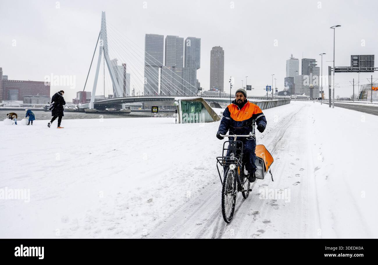 ROTTERDAM - Cyclists in the snow near the Erasmus Bridge during a ...