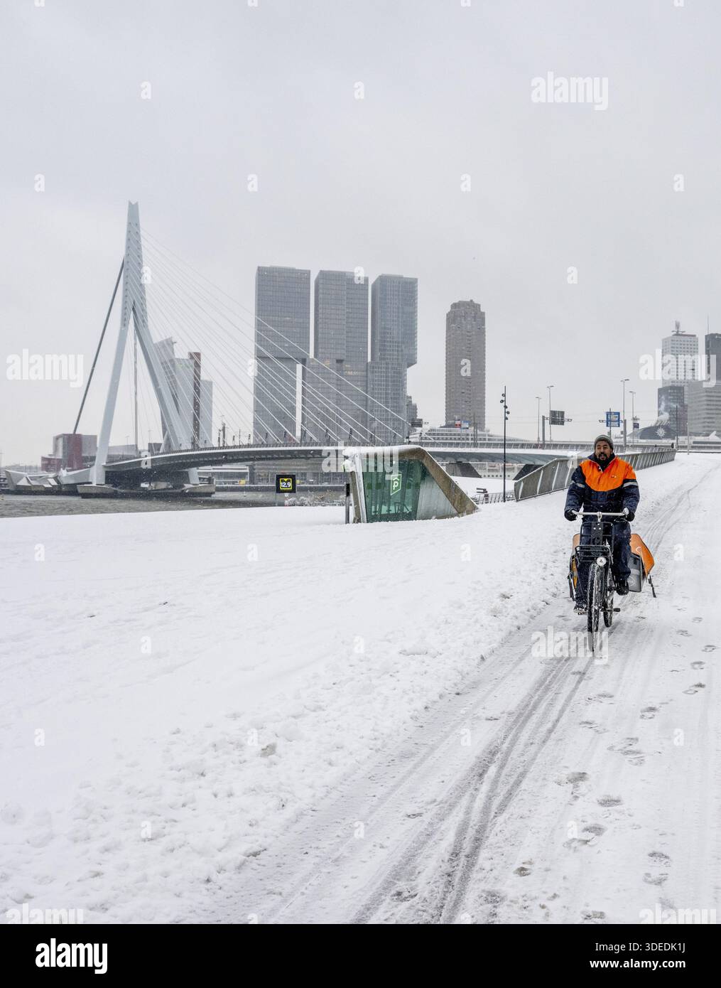 ROTTERDAM - Cyclists in the snow near the Erasmus Bridge during a ...