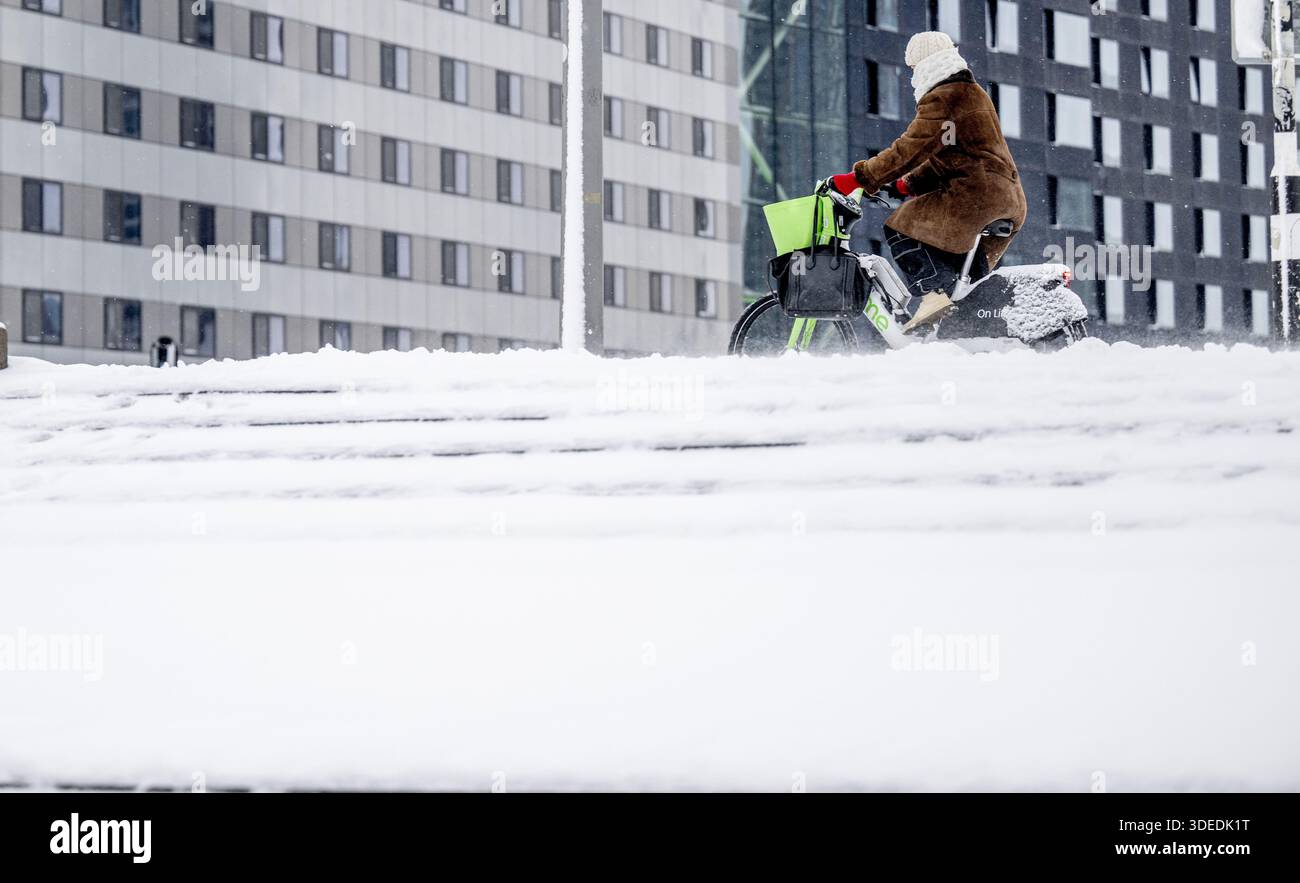 ROTTERDAM - Cyclists in the snow near the Erasmus Bridge during a ...