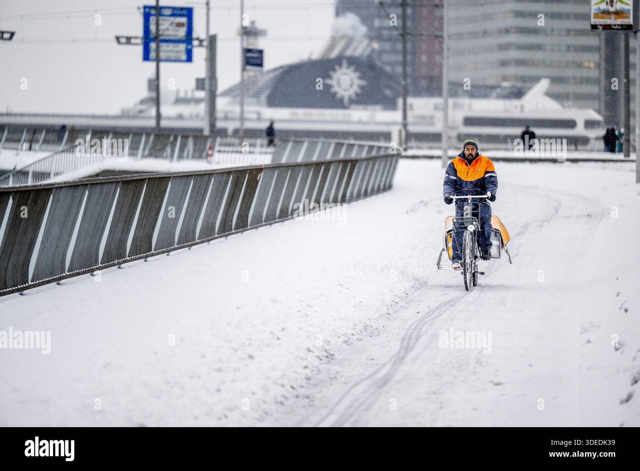 ROTTERDAM - Cyclists in the snow near the Erasmus Bridge during a ...
