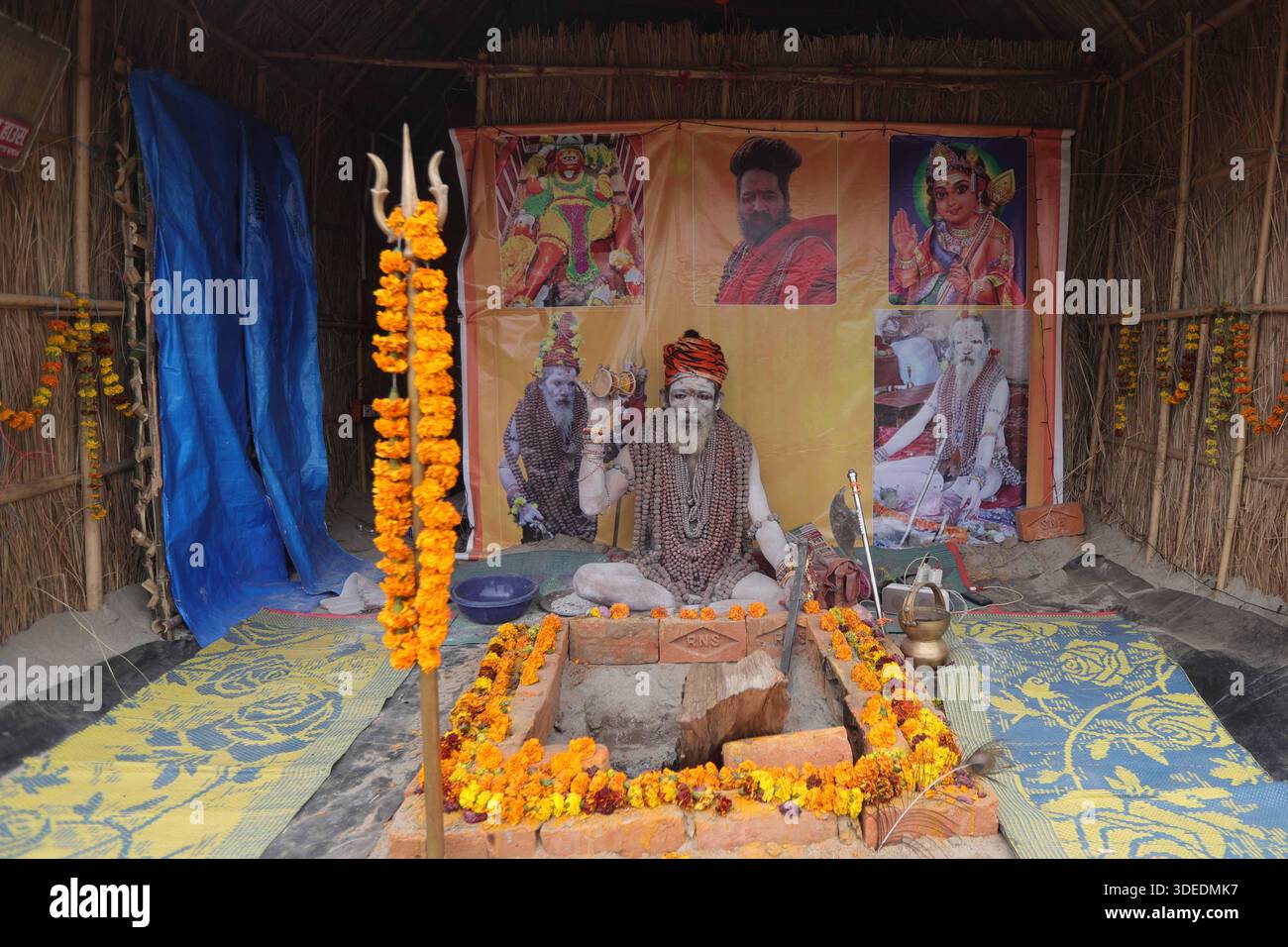A sadhu sit at his place during the 'Magh Mela 2026' at the bank of ...