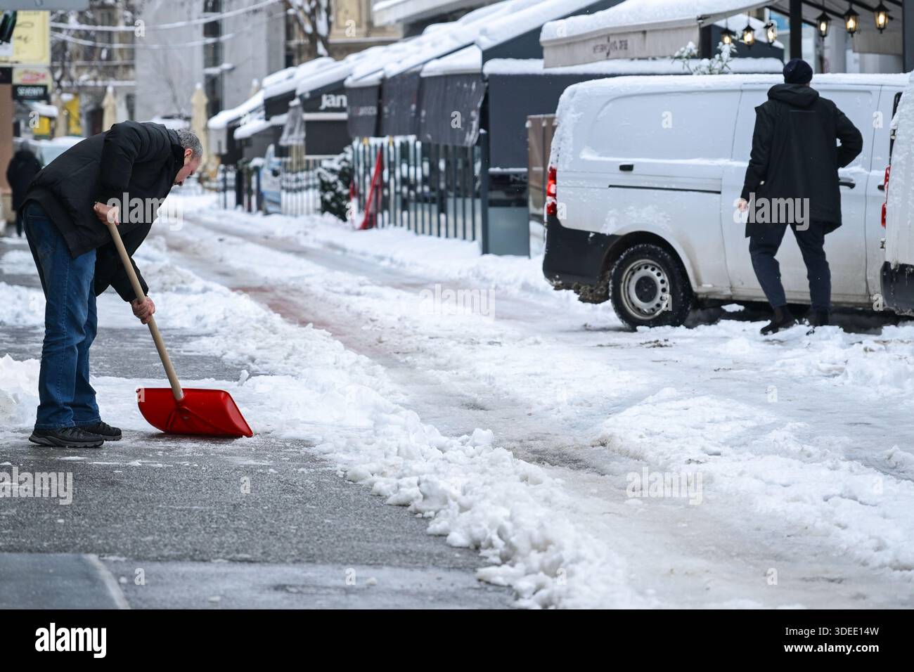 Man clears snow from a street in Zagreb, Croatia, on January 7, 2026 ...