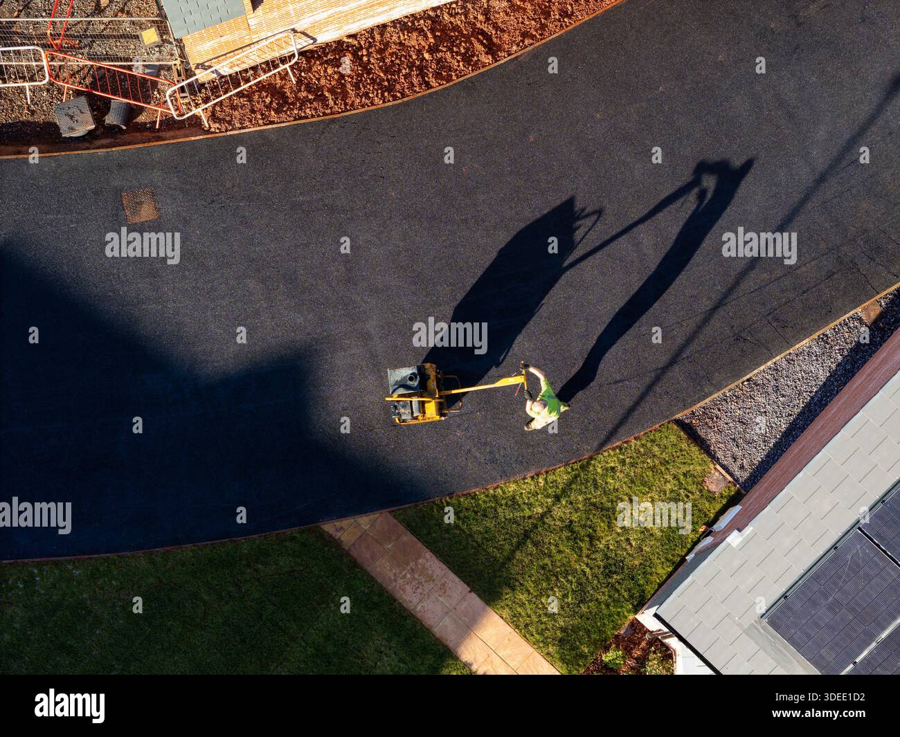a construction roadworker laying tarmac on a driveway Stock Photo - Alamy