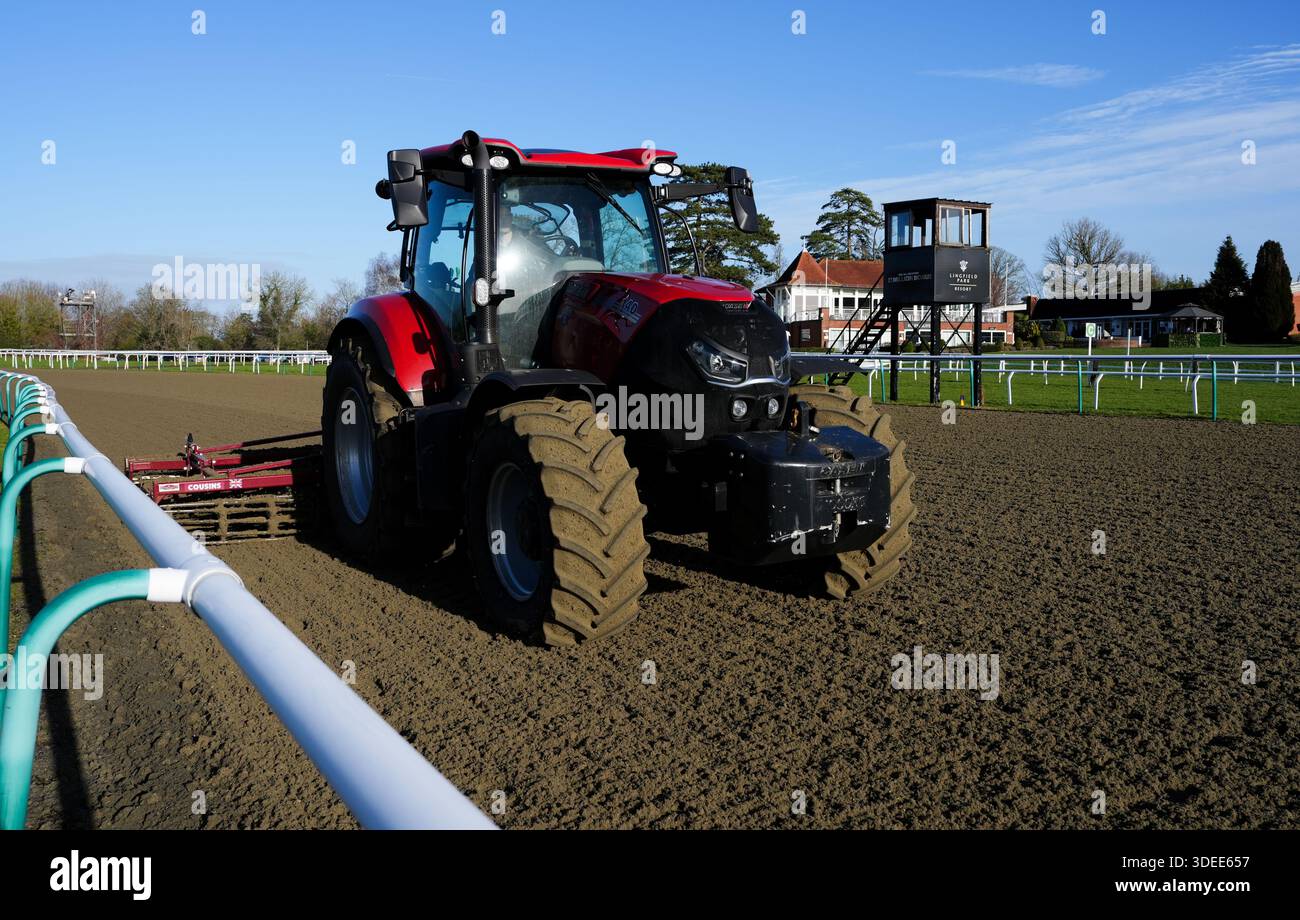 A tractor levels the track ahead of racing at Lingfield Park racecourse ...