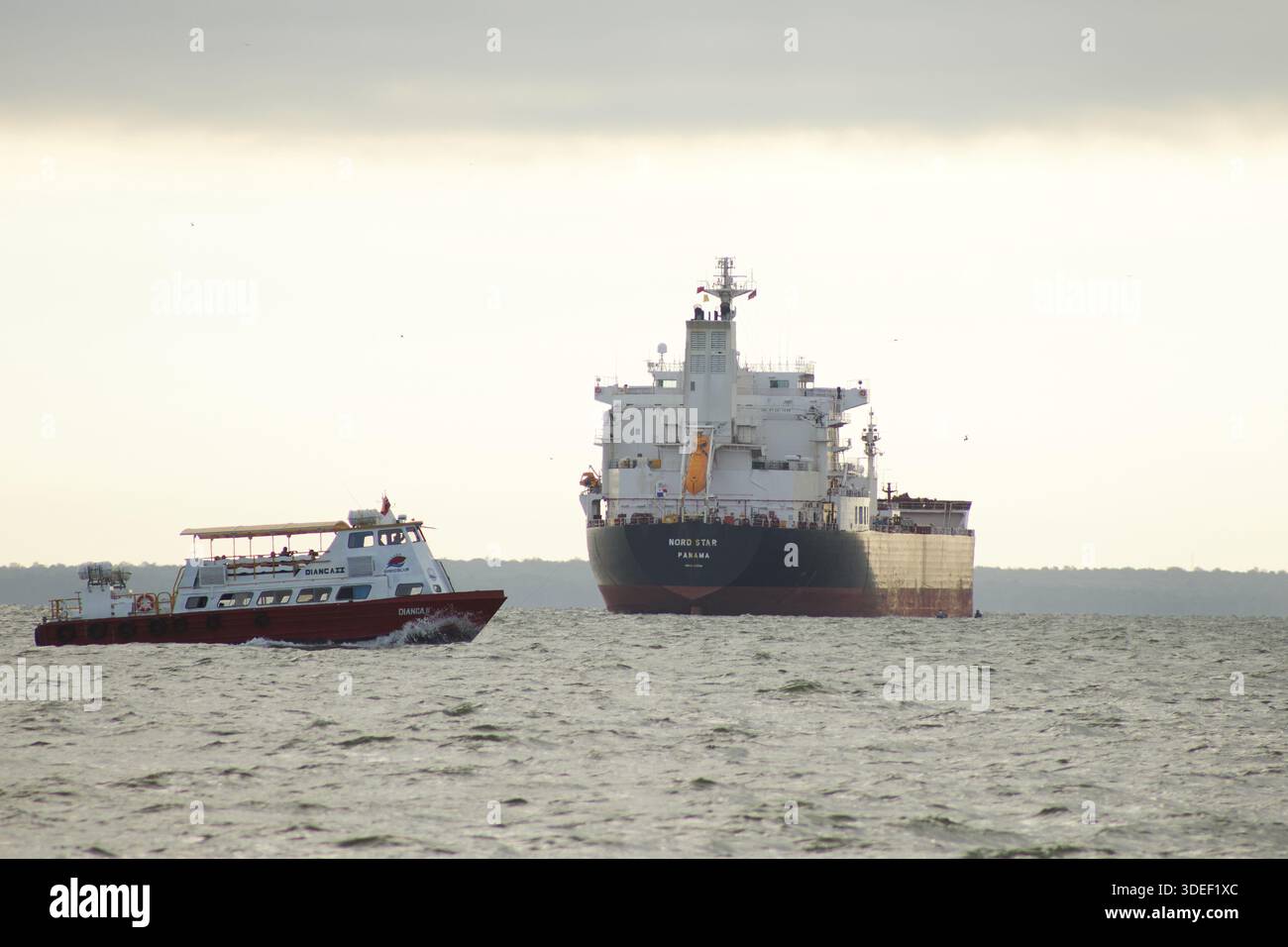 A boat sails past the oil tanker Nord Star, Panama, on Lake Maracaibo ...