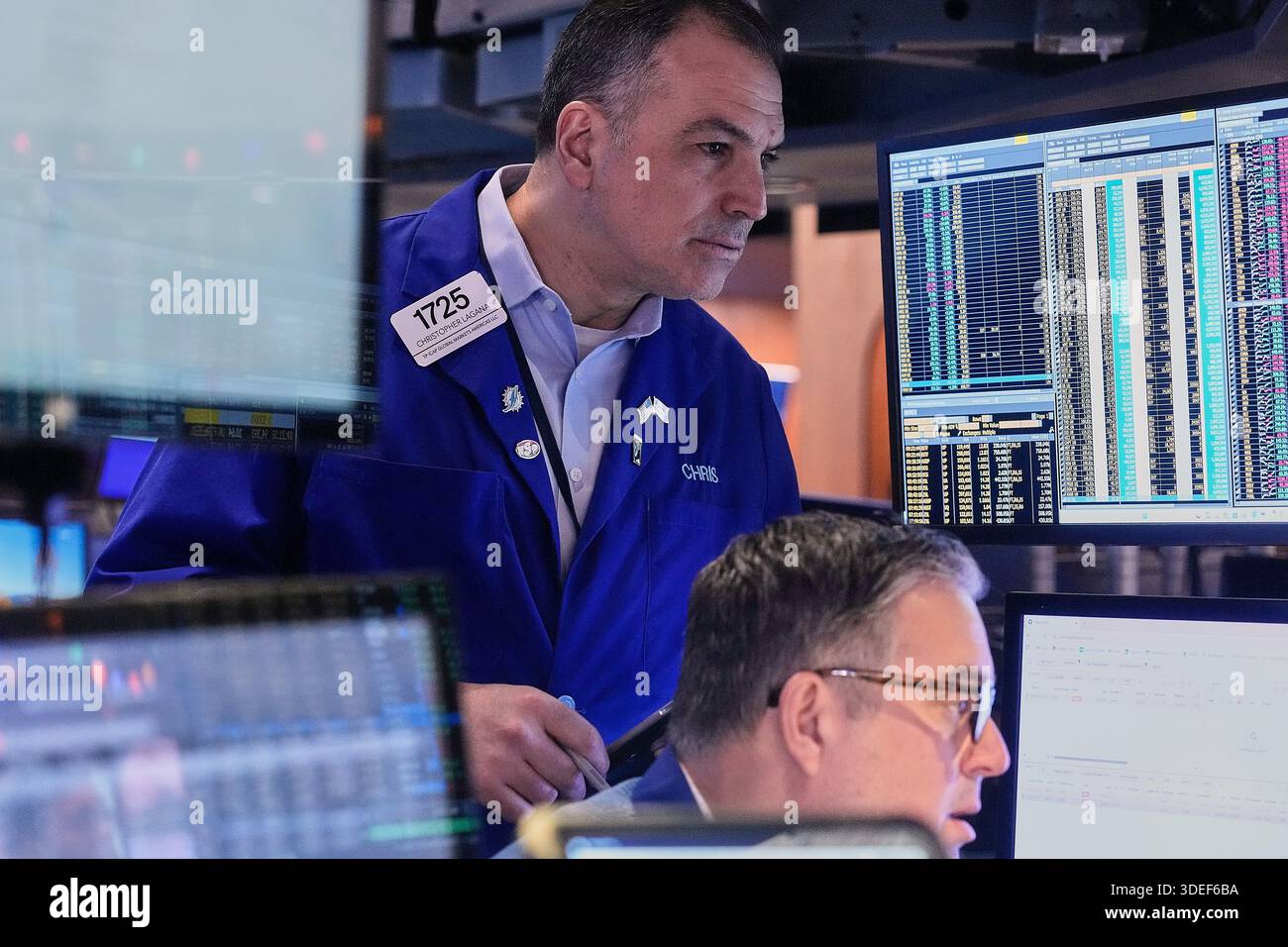 Traders Christopher Lagana, above, and James Bodner work on the floor ...