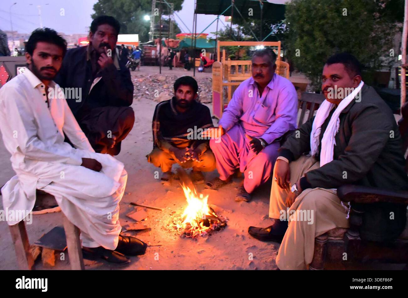 HYDERABAD, PAKISTAN, JAN 07: People are warming their hands on bone ...
