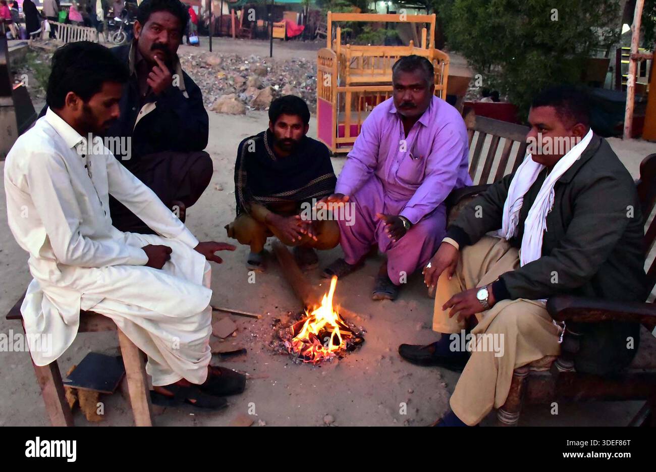 HYDERABAD, PAKISTAN, JAN 07: People are warming their hands on bone ...