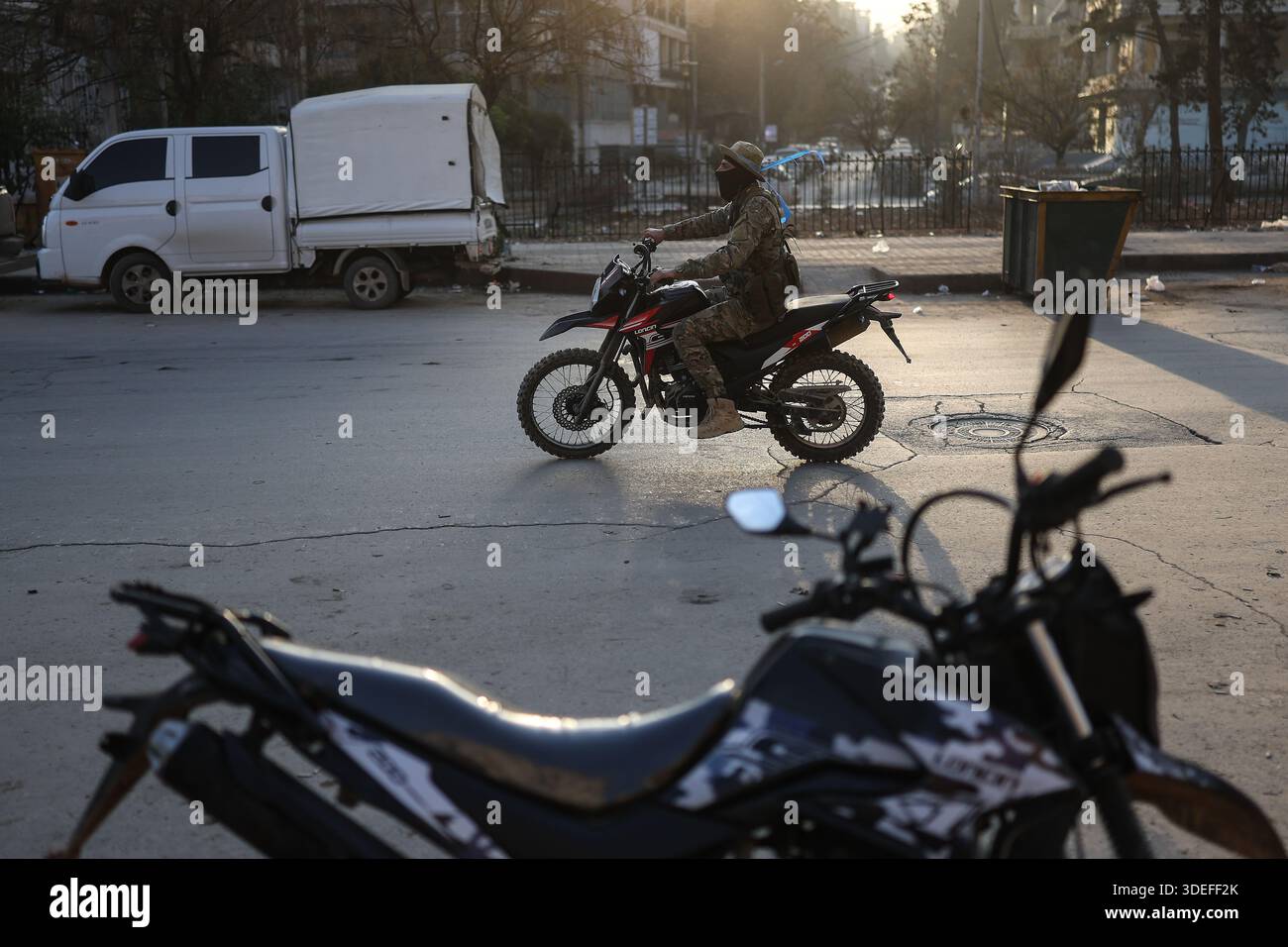 A Syrian government soldier rides a motorcycle during clashes with ...