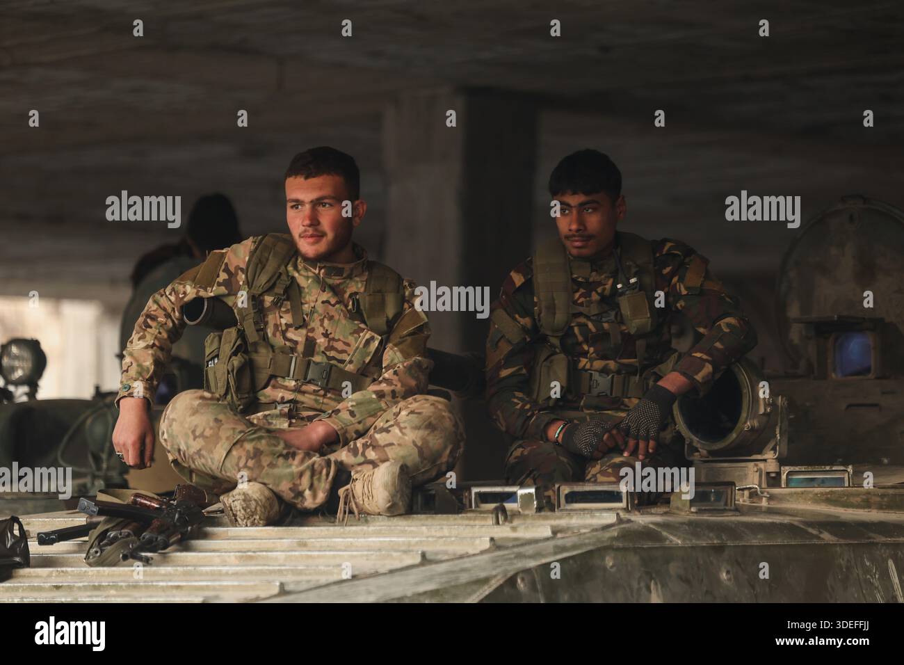Syrian government soldiers sit on their armoured personnel carrier (APC ...