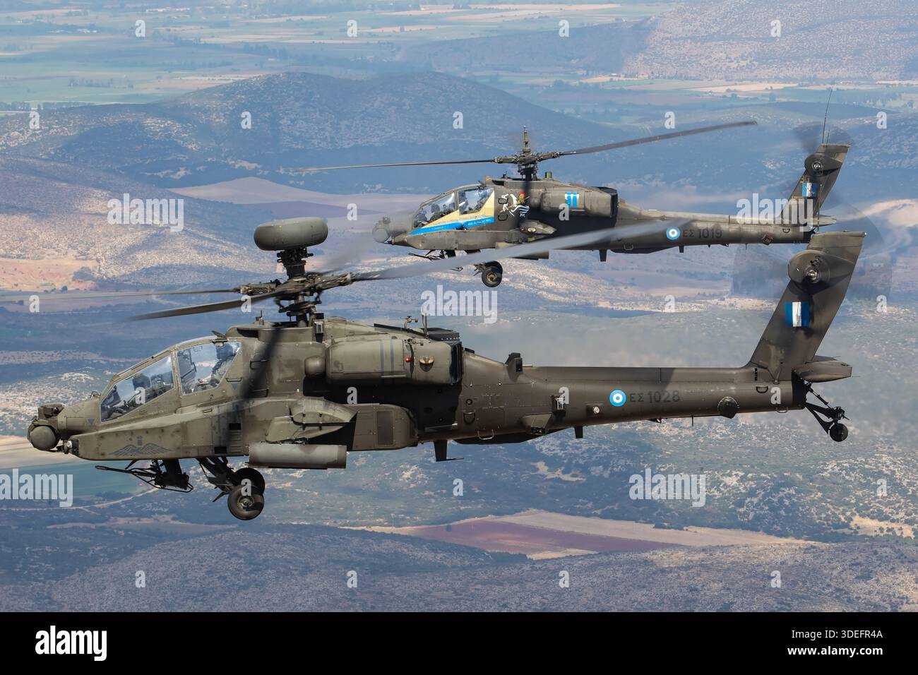 The image shows two Hellenic Army AH-64DHA Apache Longbow helicopters ...