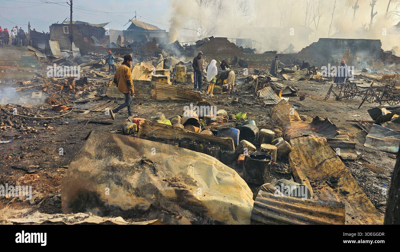 People try to salvage belongings from the charred remains after a fire ...