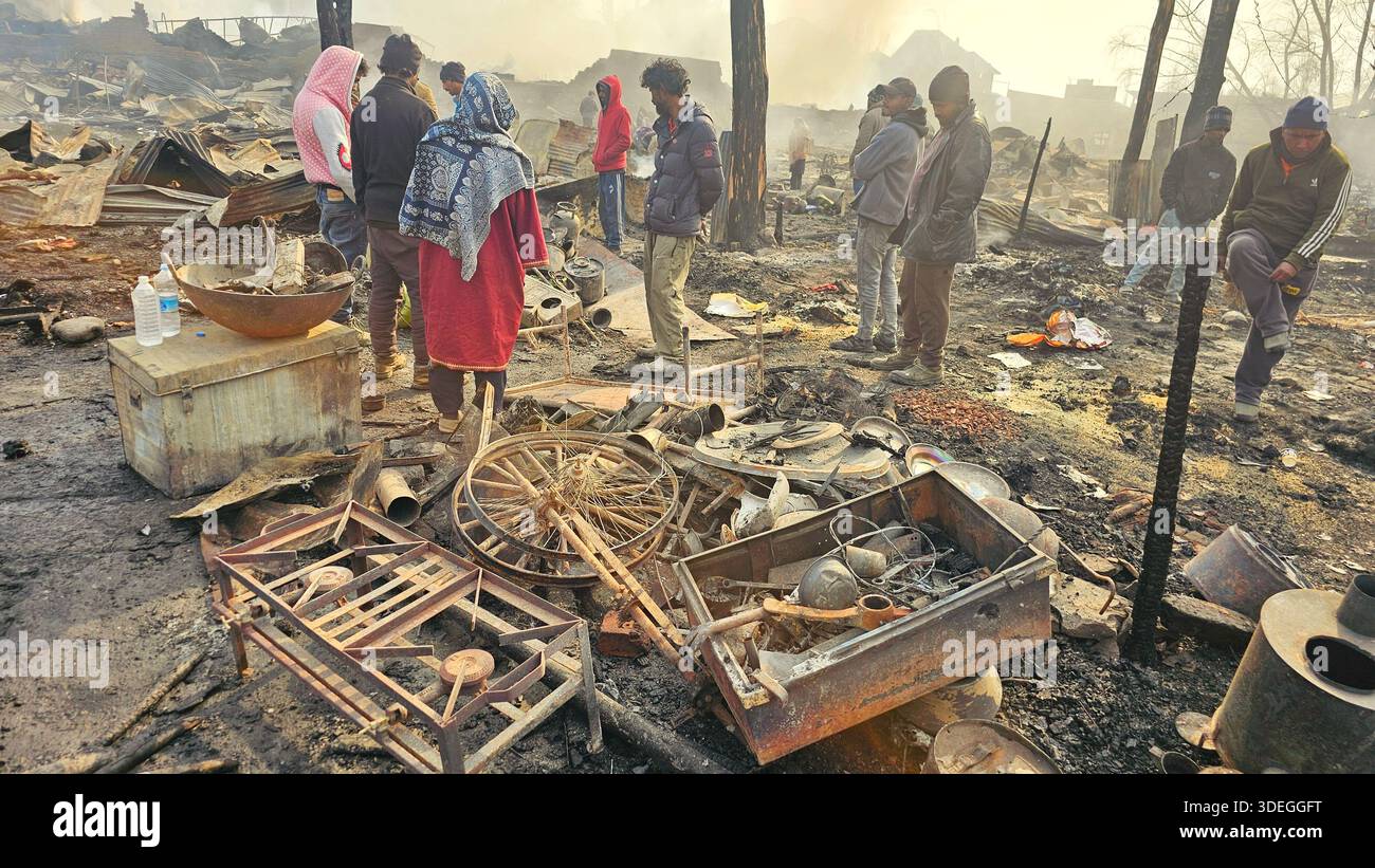 People try to salvage belongings from the charred remains after a fire ...